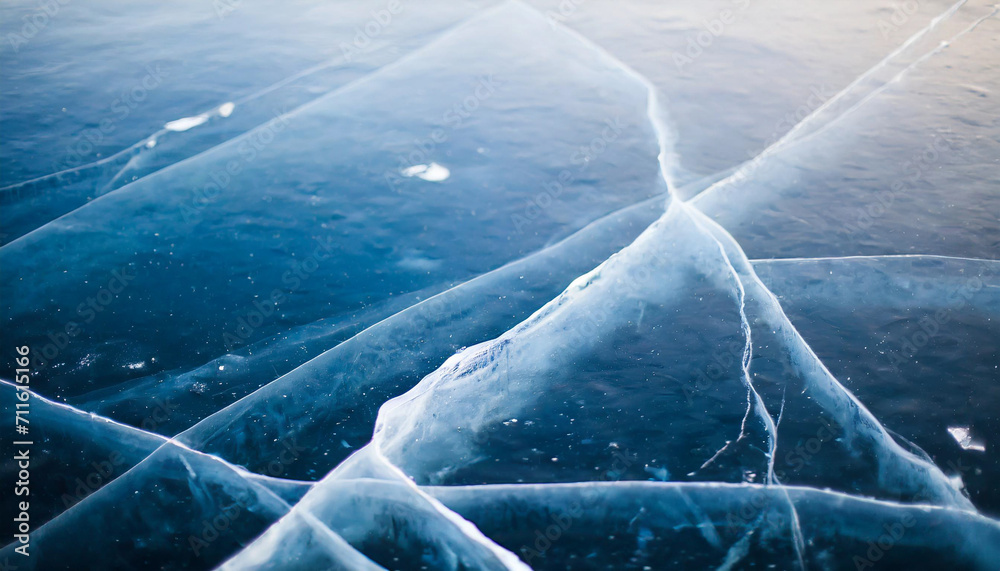 transparent blue ice on a frozen lake with intricate cracks, creating ...