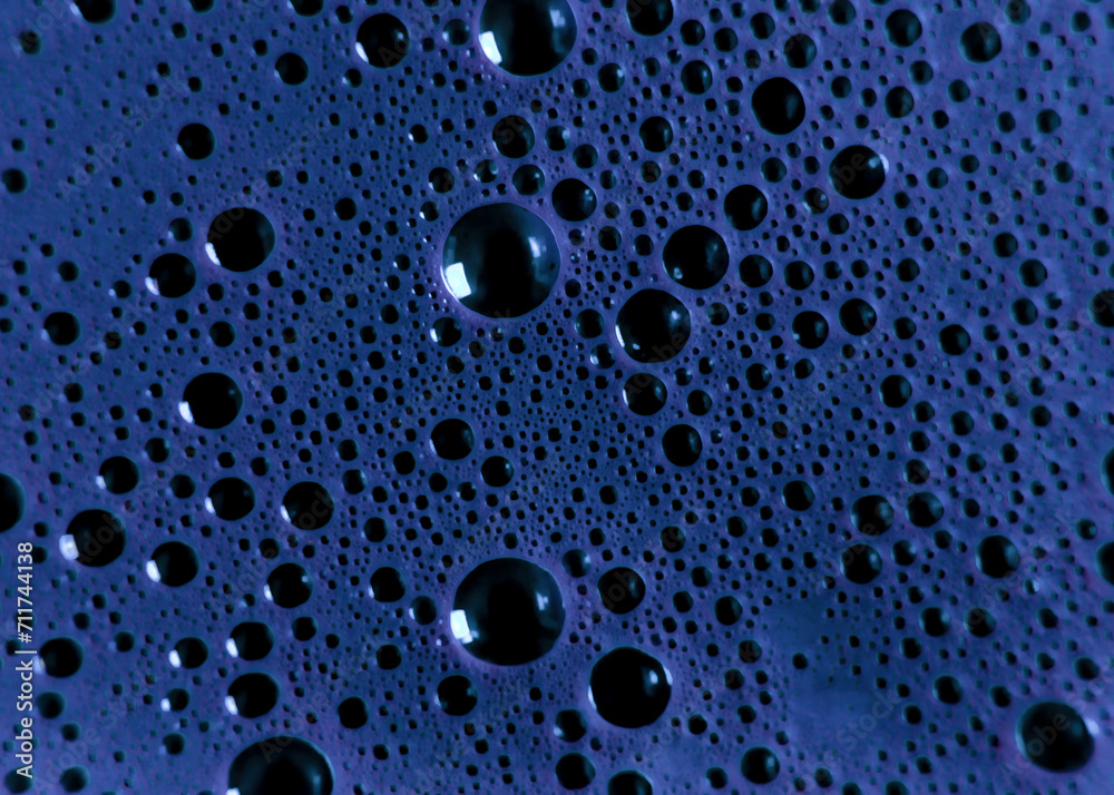 Abstract surface of floating bubbly spheres in a blue liquid. Cold ...