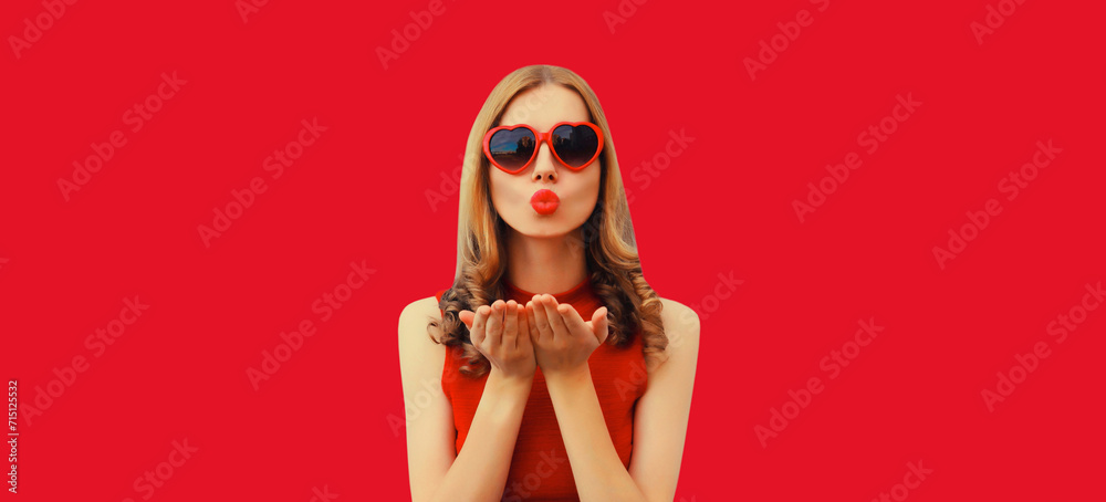 Portrait of beautiful young woman blowing her lips with red lipstick ...