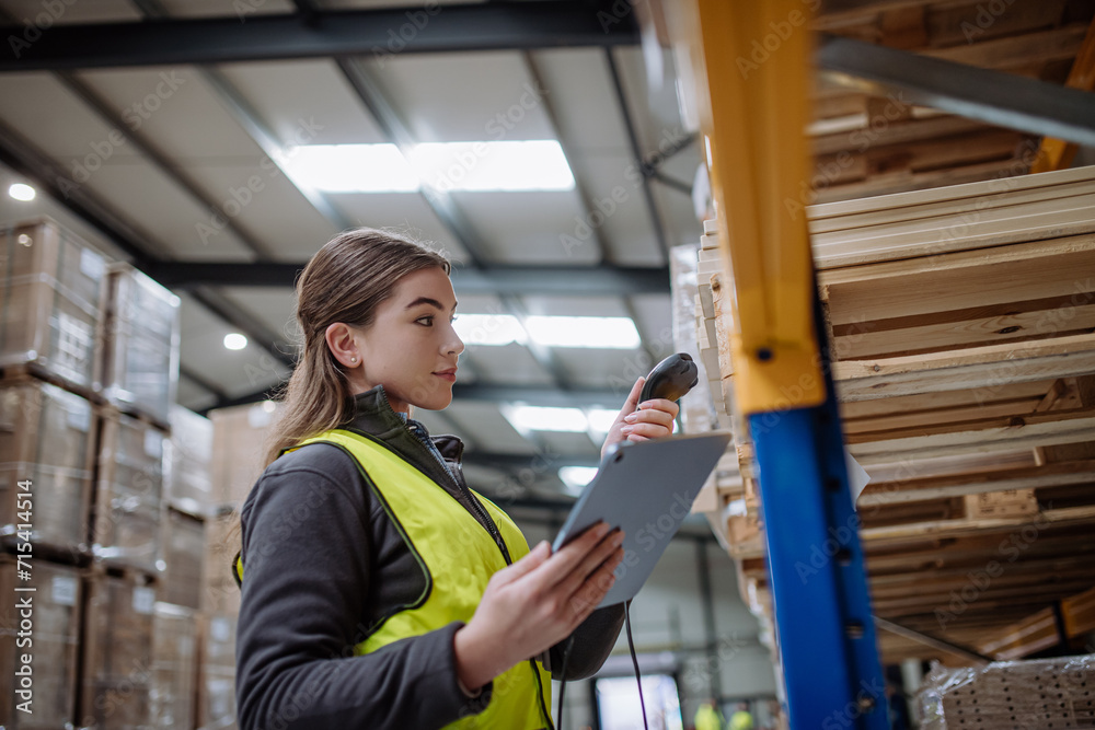 Female warehouse worker holding scanner, scanning the barcodes on ...