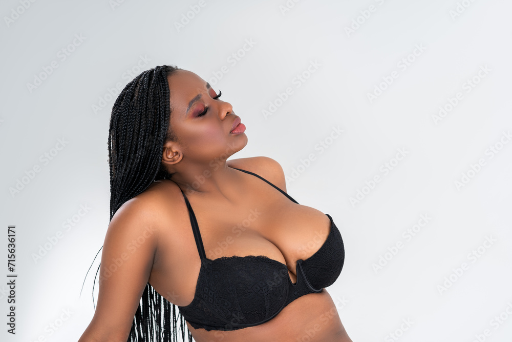 Curvy busty plus size model in push up bra on gray background, overweight African black woman in ...