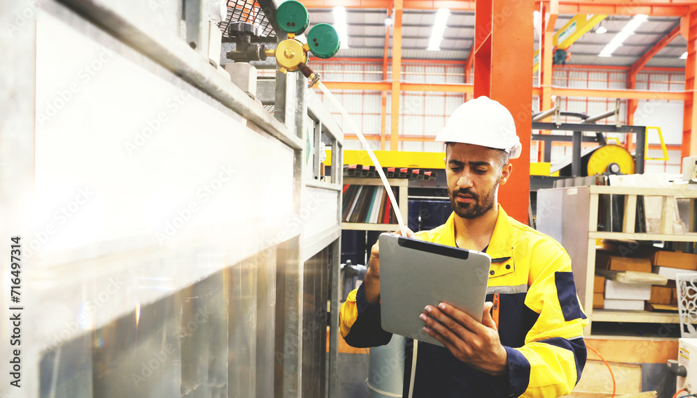 Factory safety : Male technician engineer wearing helmet holds tablet ...