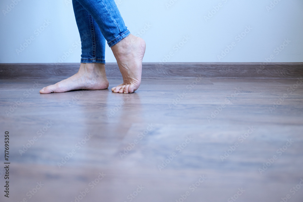 Side view of unrecognizable female feet, barefoot girl standing indoors ...