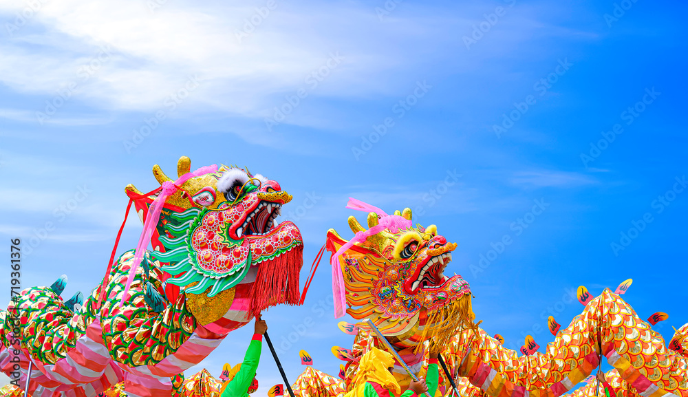Two colorful Chinese dragon dance performances against blue sky ...
