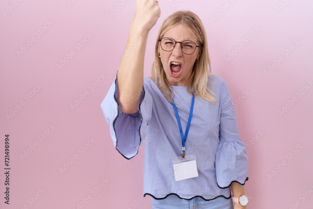 Young caucasian business woman wearing id card angry and mad raising ...