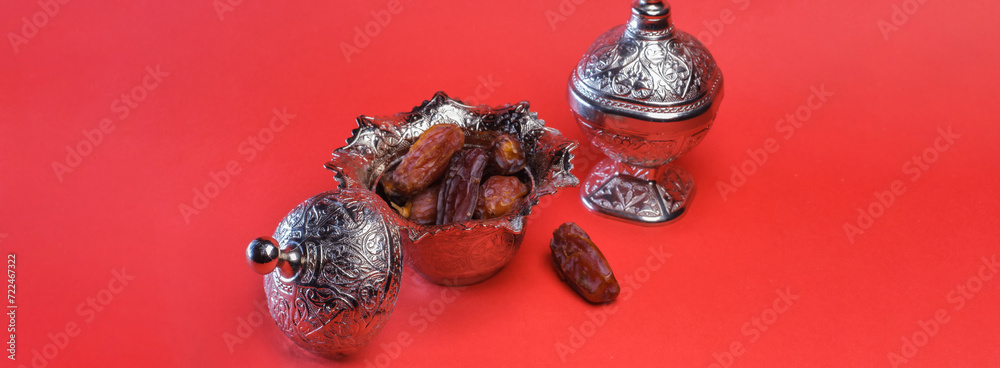 Dates in a silver bowl on a red background. An image of the month of ...