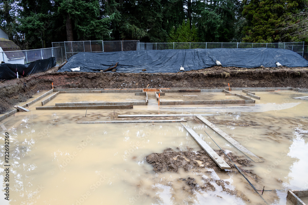 Under construction, residential house foundation dug out and framing ...