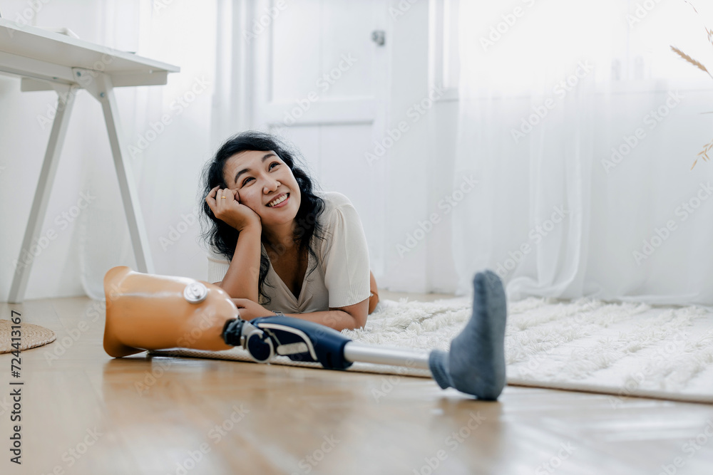 Woman with trying catch prosthetic leg on floor in bedroom. People with ...