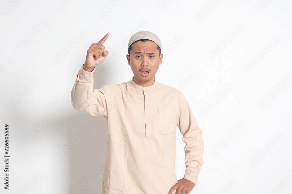 Portrait of attractive Asian muslim man in koko shirt making angry hand ...