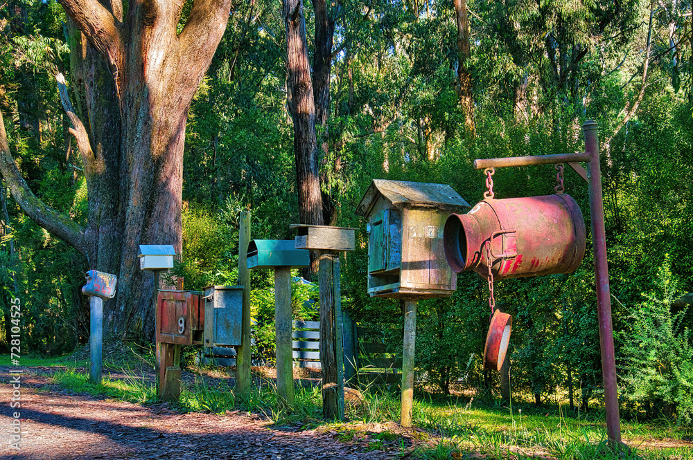 Row of individualistic rural letterboxes by the roadside of a country ...