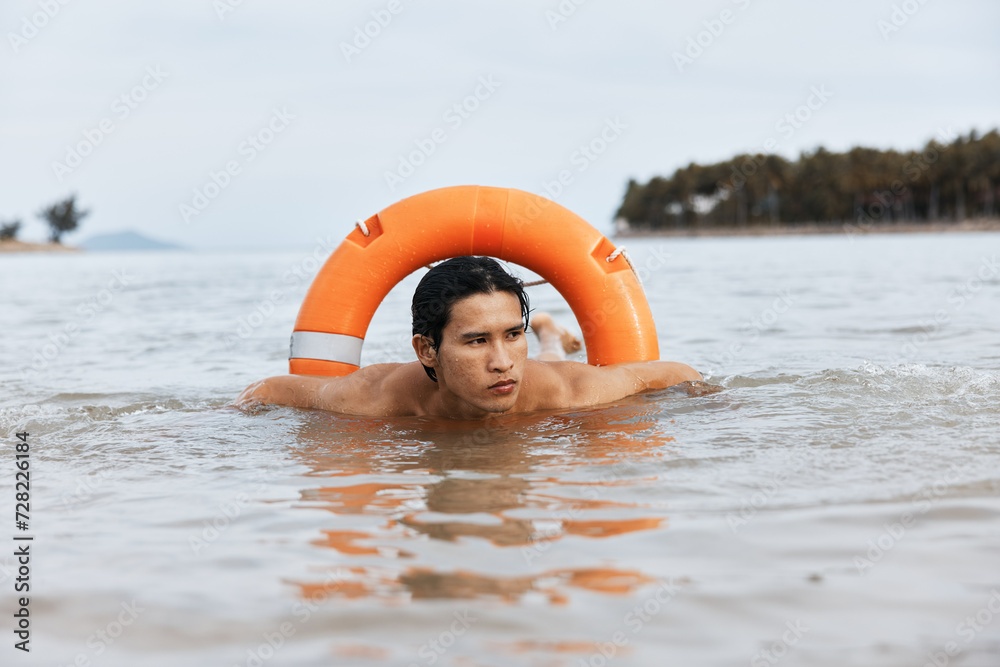 Guardian of the Sea: A vigilant lifeguard ensures safety as he watches ...