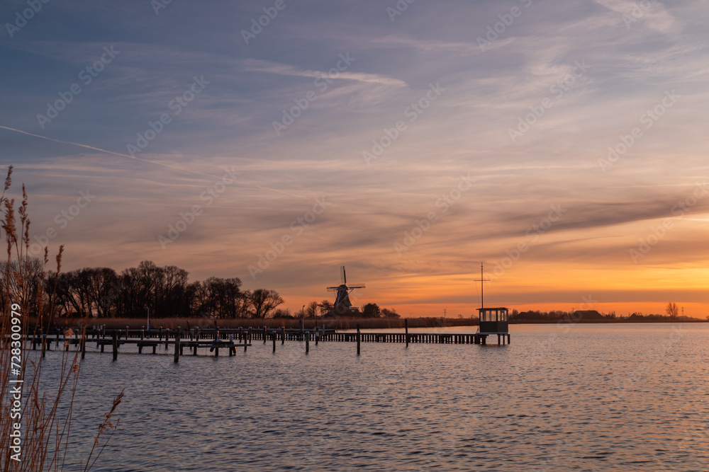 Oude Veer marina and Windmill Leonide during a spectacular sunset. Due ...