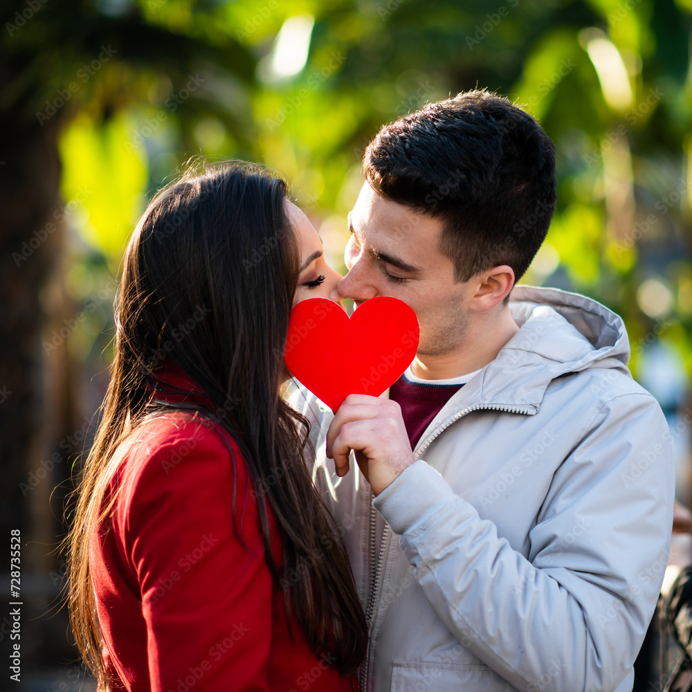 Romantic couple sharing a kiss behind a heart Stock Photo | Adobe Stock