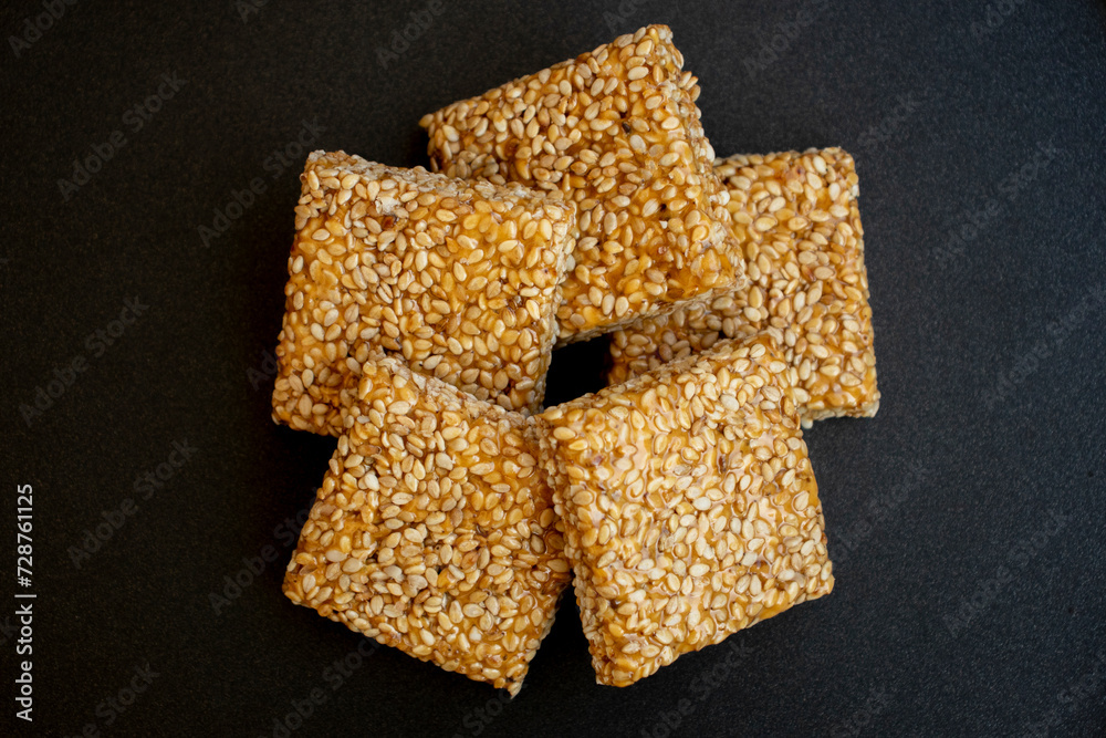 Til chikki on black textured background. Til chikki is an Indian sweets ...