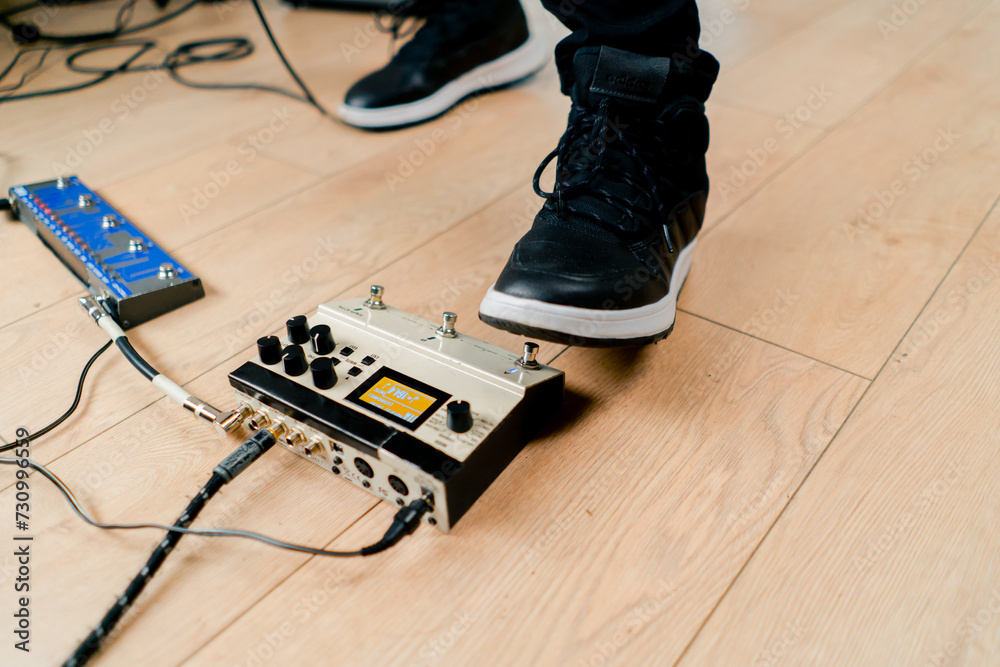 musician's male foot pressing bass drum pedal or bass electric guitar ...