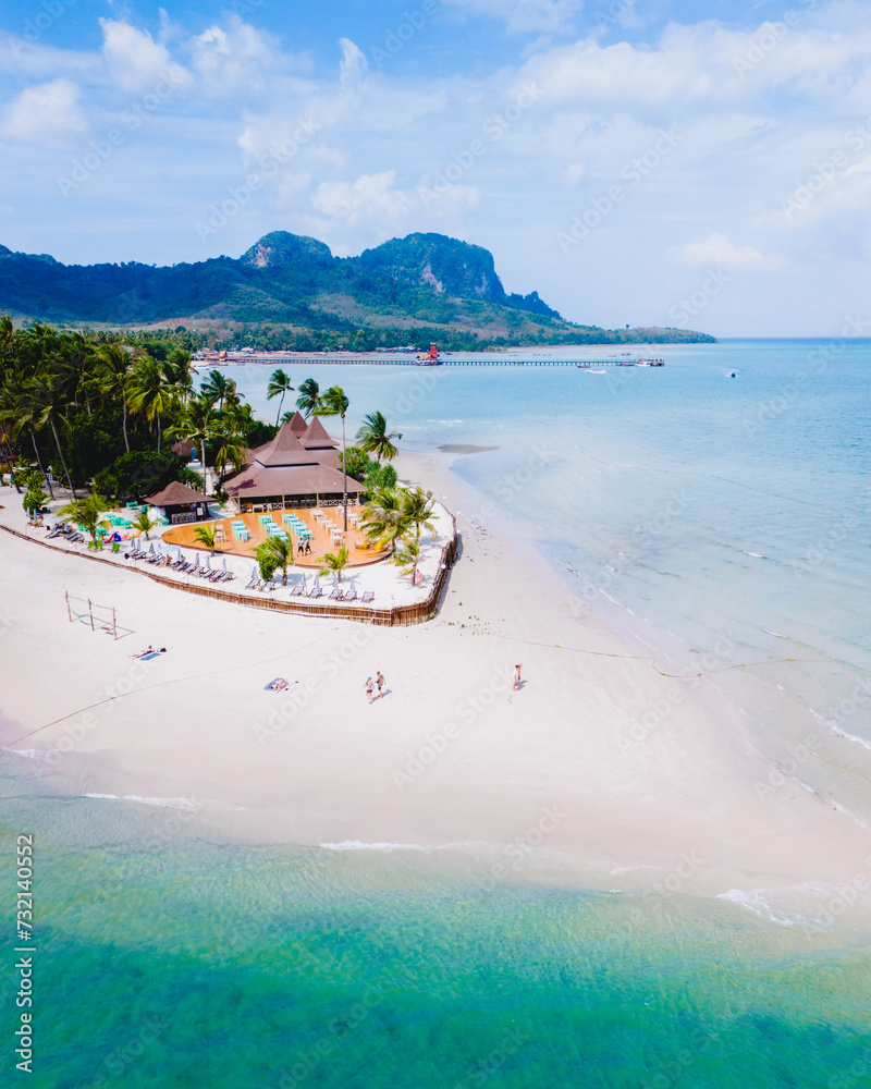 couple at a sandbar in the ocean of Koh Muk a tropical island with palm ...