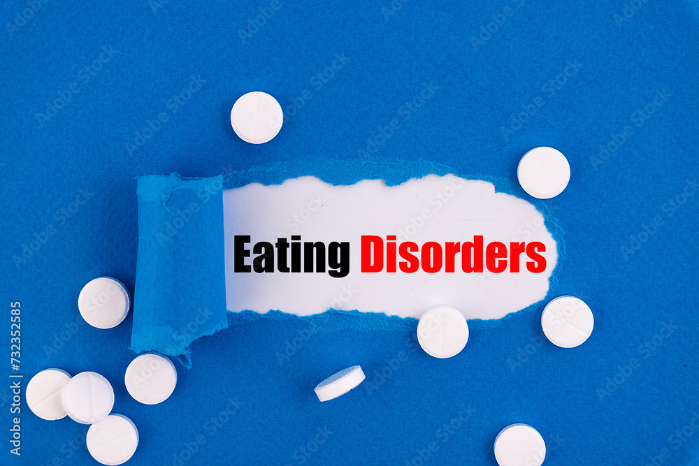 The text Eating disorders appearing behind torn blue paper. Stock Photo ...