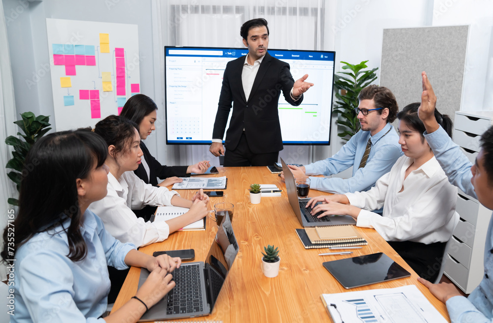 Corporate employee raise hand ask question during project meeting ...