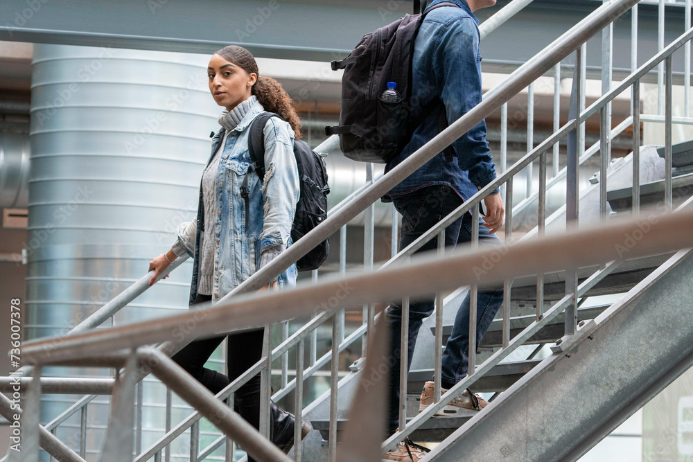 Male and female mixed race student standing at the stairs of her ...