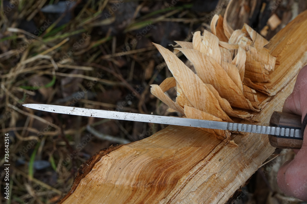 A sturdy fixed blade knife is used for whittling and making feather ...