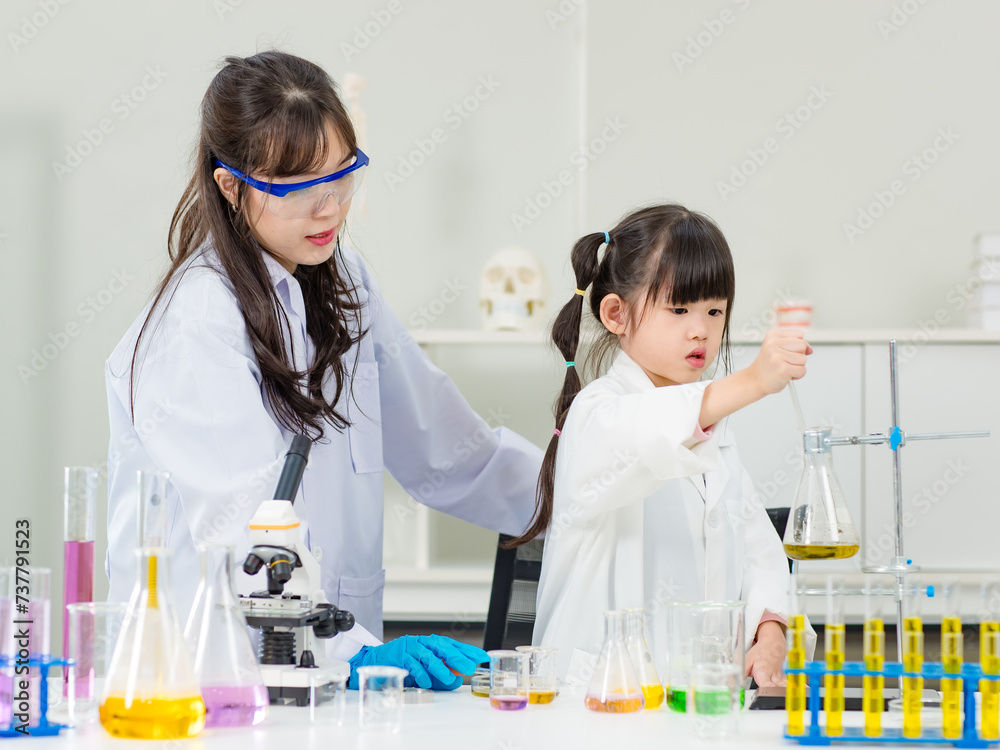 Asian woman teacher and little children girl making science experiments ...