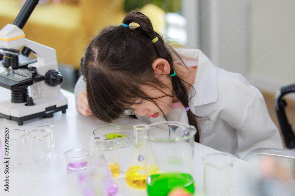 Asian little cute girl students in lab coat thinking making test tube ...