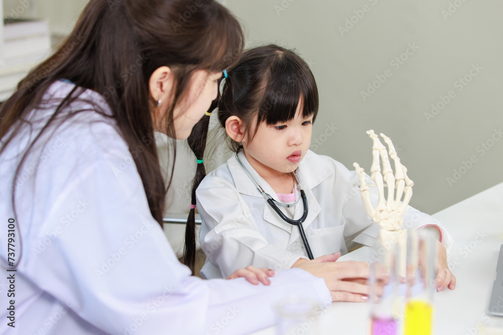 Asian woman doctor physiotherapist explains human fake body skeleton ...