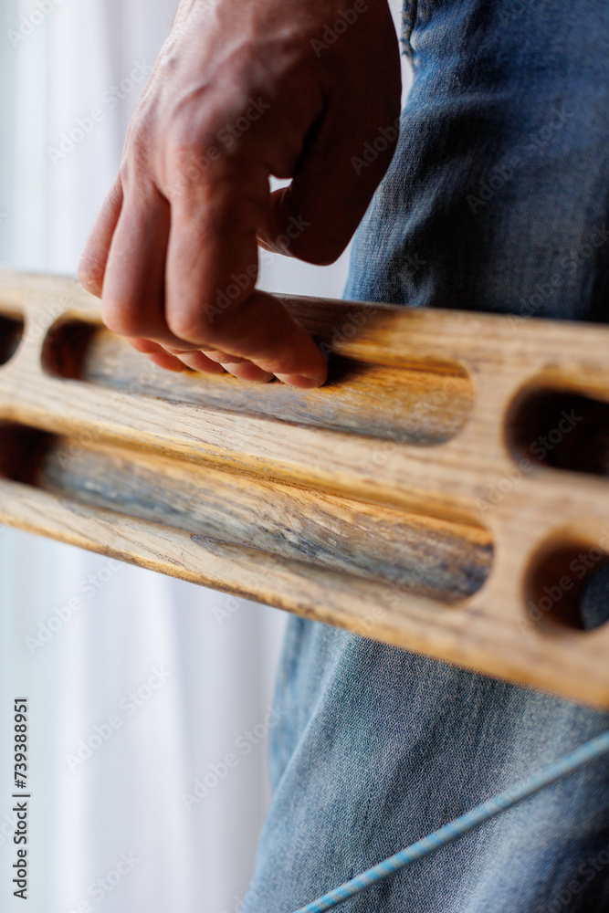 strong male hand of a rock climber holds a board for training finger ...