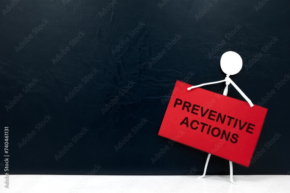 Stick figure holding preventive action placard in black background ...
