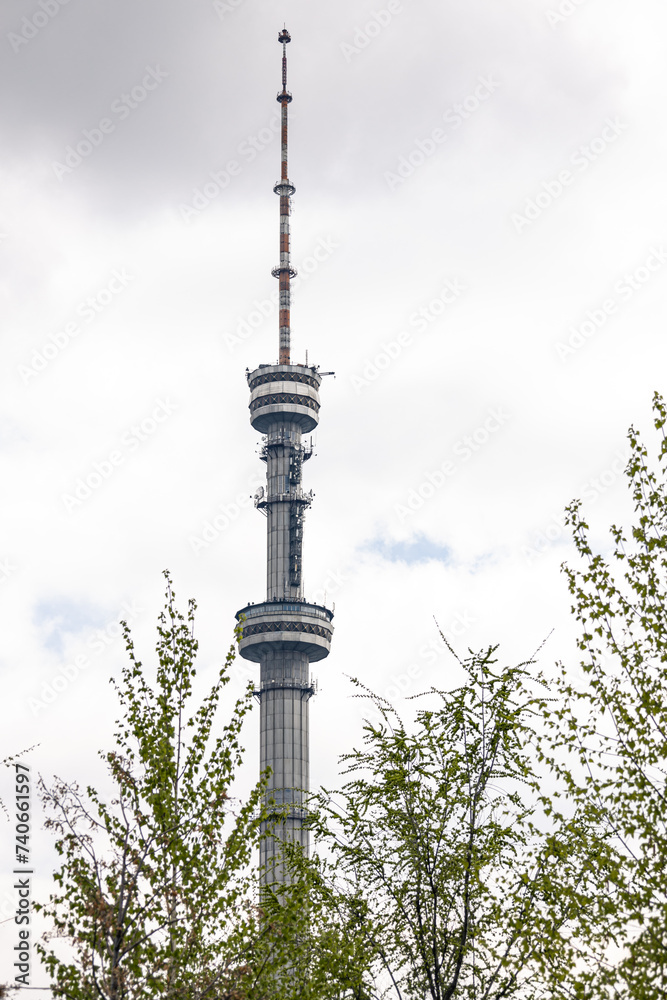 Tall large building, view of tv-tower through the tree branches ...