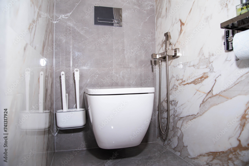 The interior of a modern toilet with gray porcelain tiles on the walls ...