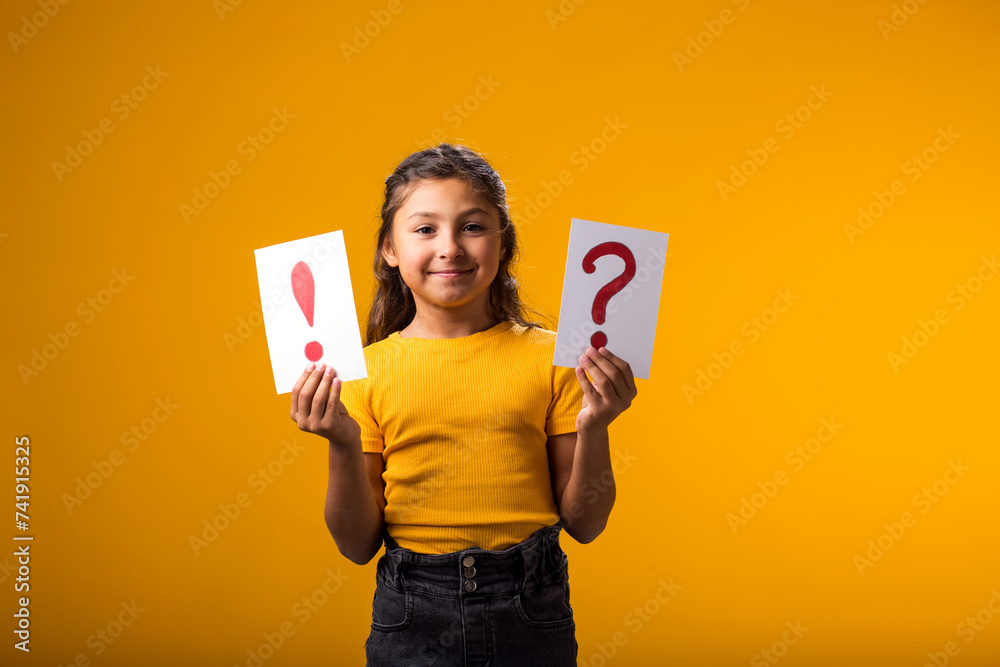 Smiling kid girl holding cards with question mark and exclamation point ...