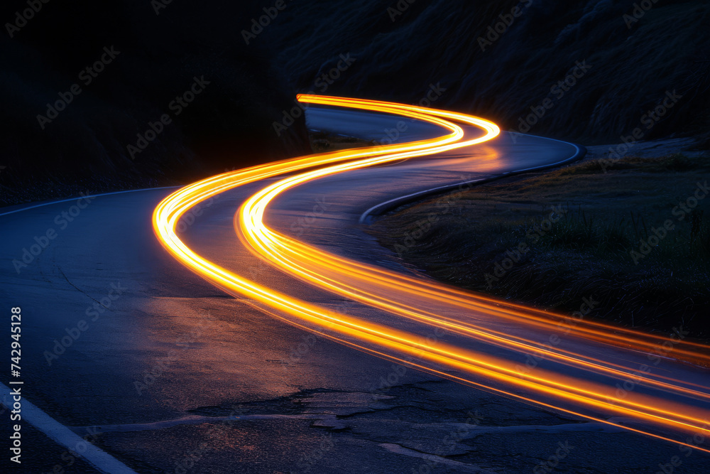 Car headlight marks illuminate the night as they leave a trail along ...