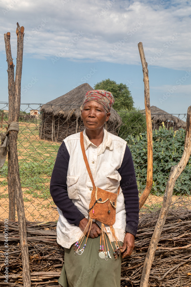 village old african woman in the yard, with traditional bag, in the ...