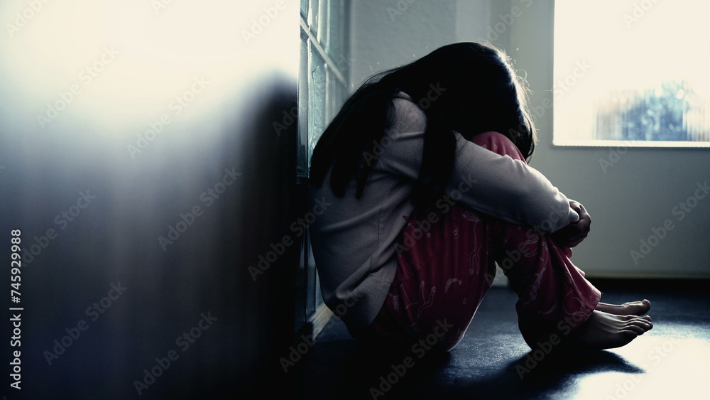 Sad child suffering from depression sitting alone in corridor feeling ...