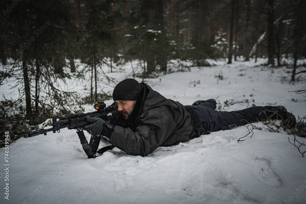 A private military man, in a prone position, aims from an AK-12 assault ...