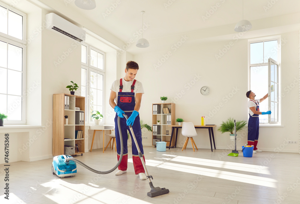 Team of cleaning service workers tidying up office or apartment. Two ...