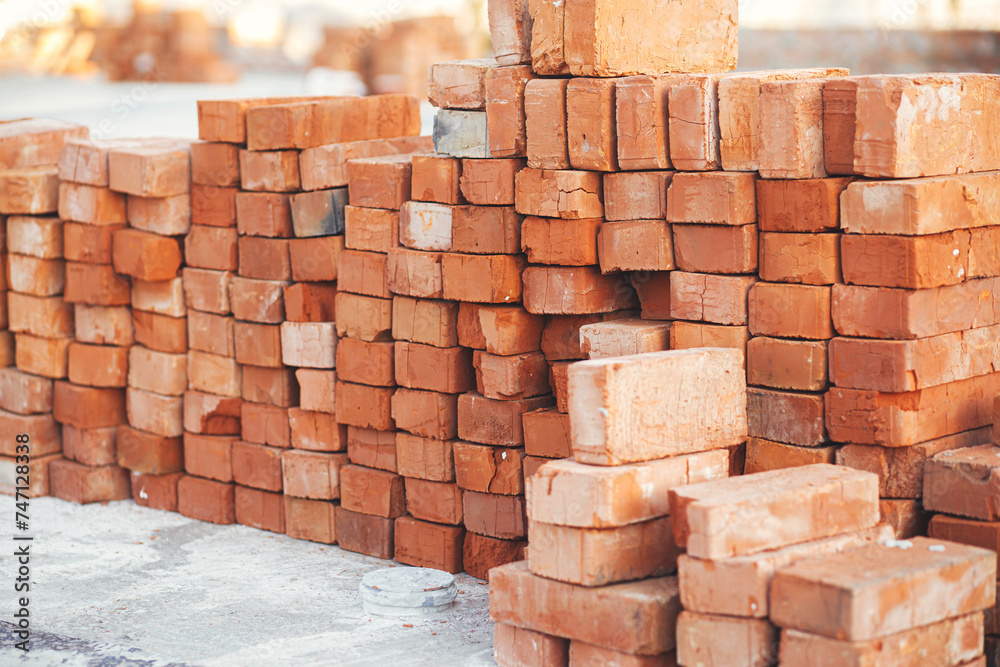 Stack of red bricks on concrete foundation, process of house building ...
