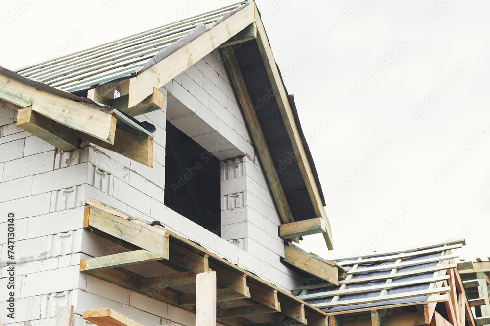 Unfinished house. Wooden roof framing with vapor barrier and dormer on ...