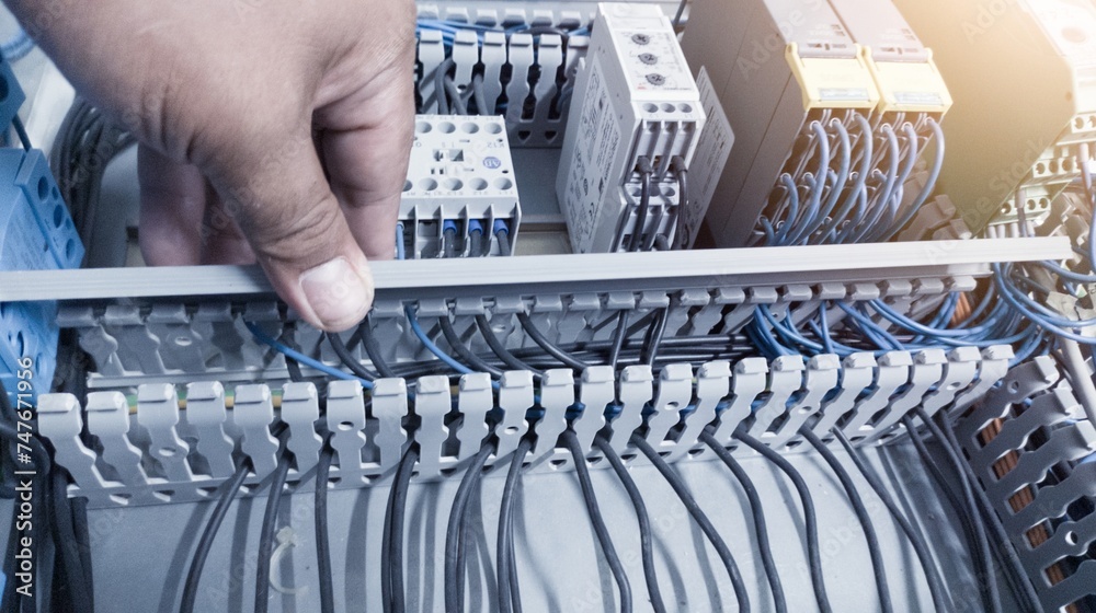 an electrician's hand is opening or closing the circuit cable cover on ...
