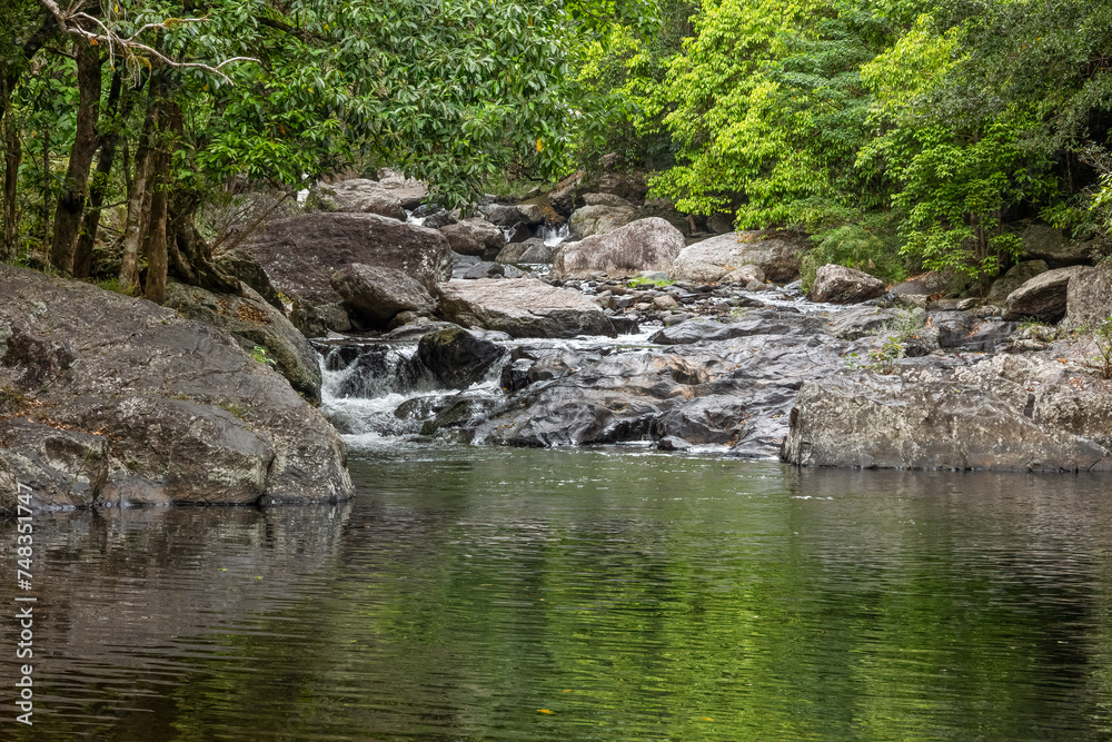Creek water cascades down a rock formation into a beautiful swimming ...