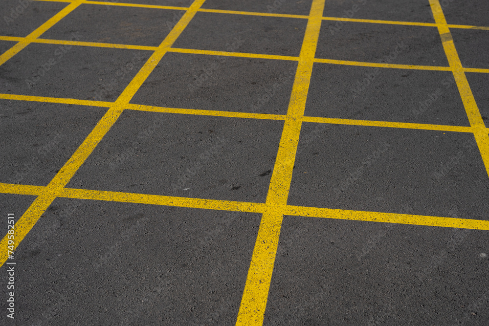 Diagonal yellow lines forming a grid at an asphalt road. Prohibition on ...