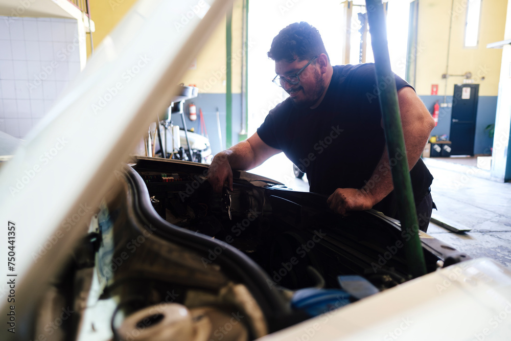 Auto mechanic working on car engine at workshop Stock Photo | Adobe Stock