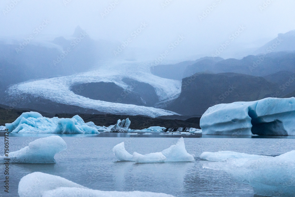 Icebergs drift in the hushed waters of a glacial lagoon with ...