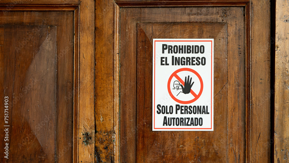 No trespassing sign at the entrance of a shop, above a wooden door ...