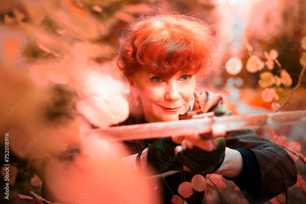 Mature model portraying a royal huntress with red curve hair is hunting ...