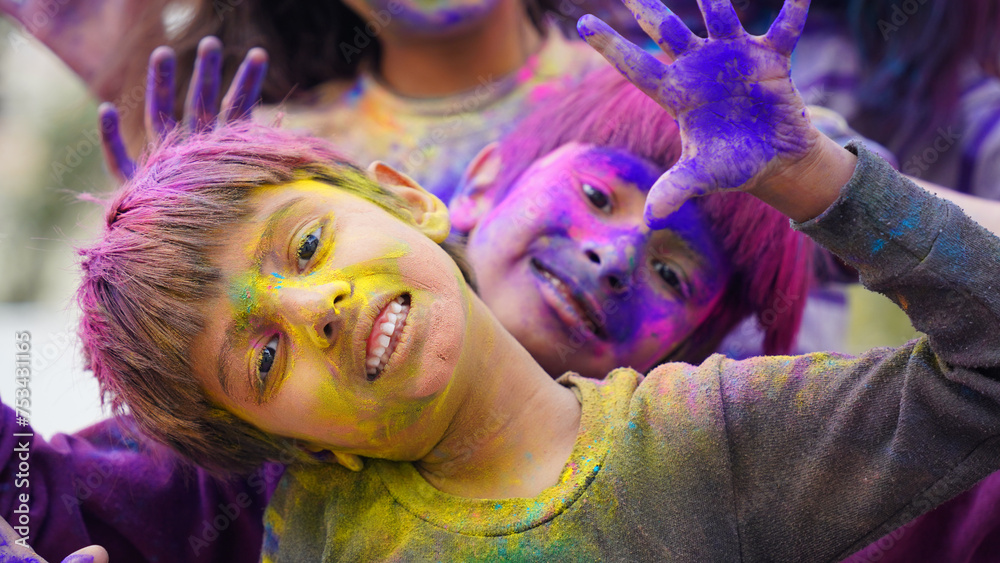 Indian kids playing with colours or asian children celebrating holi ...