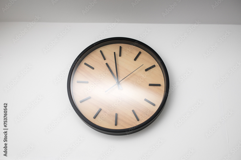 Stock-Foto „White wall and black wall clock with wood elements. Clock ...