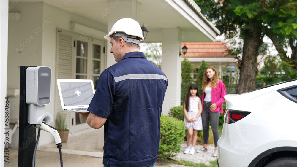 Qualified technician working on home EV charging station installation ...