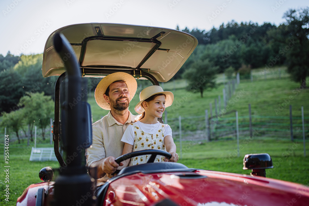 Farmer father riding tractor with his daughter. Girl growing up on ...